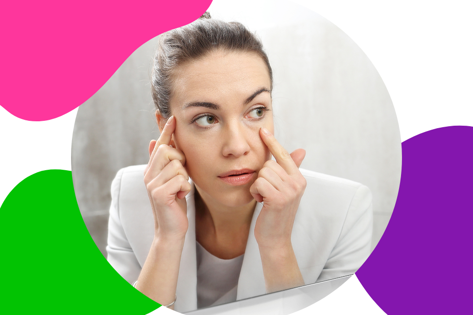 junge Frau mit braunen Haaren schaut sich im Spiegel ihre vergrößerten ...